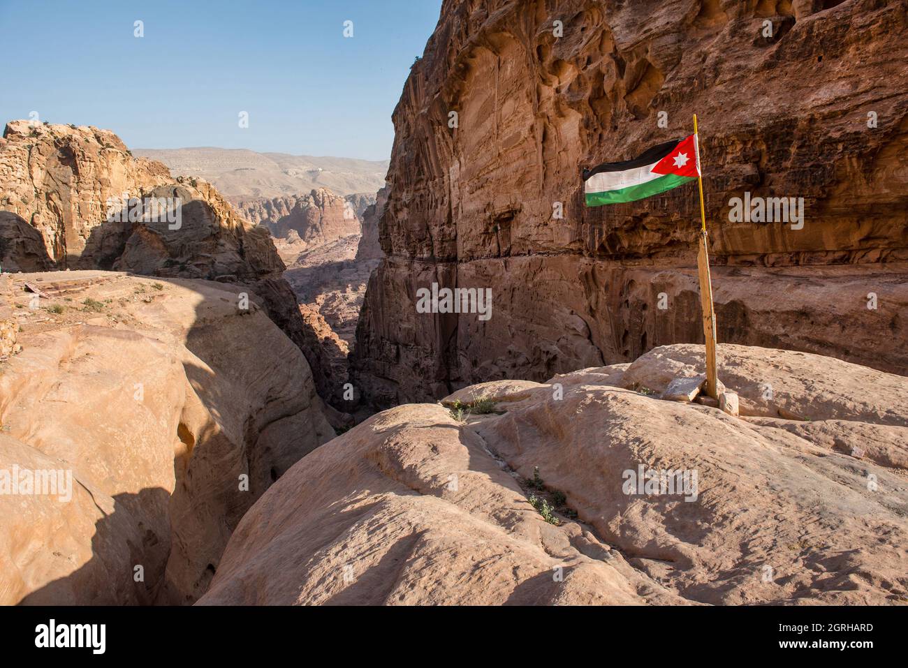 Jordanian Flag Waving On Cliff Against Clear Sky Stock Photo - Alamy