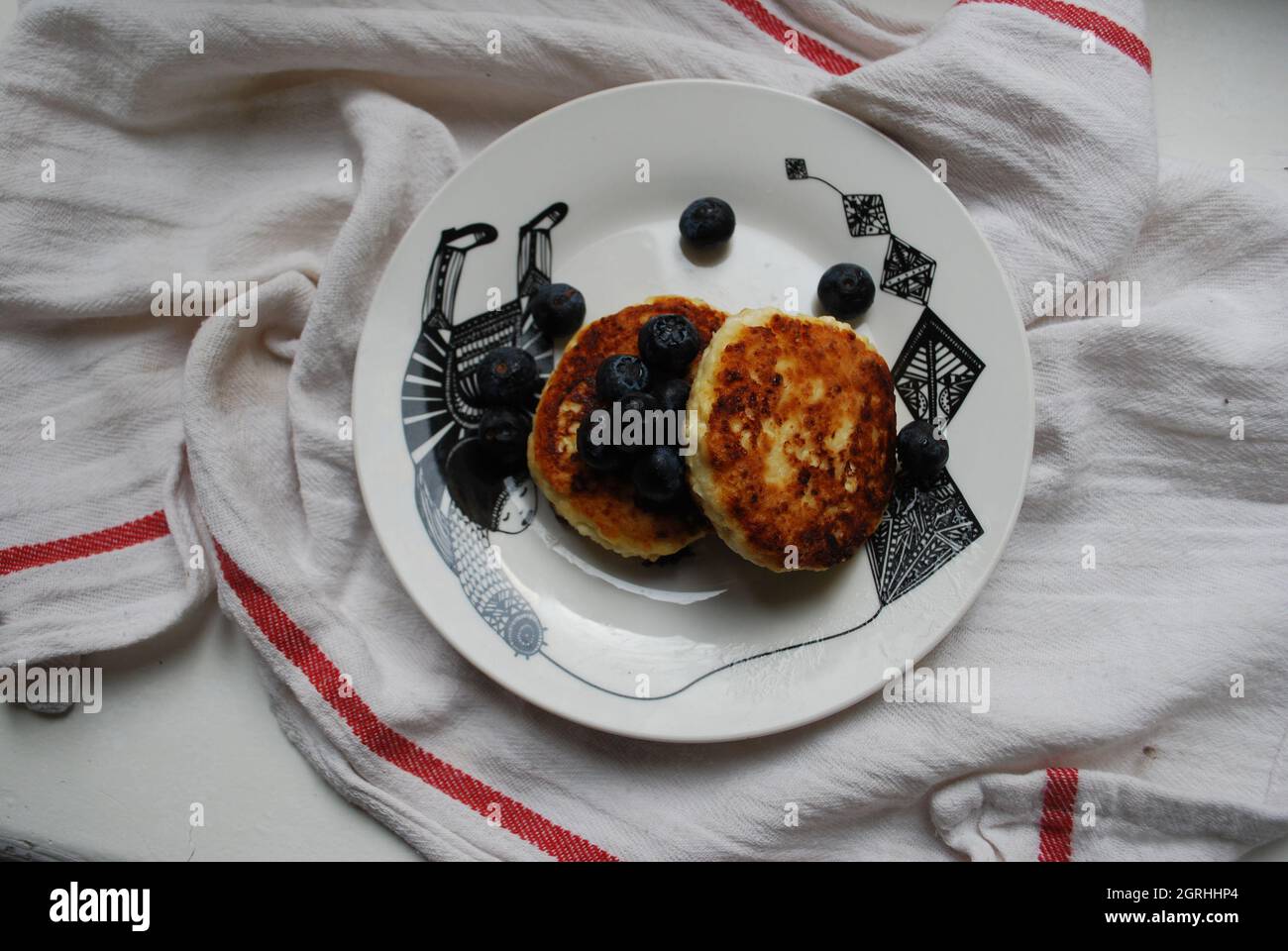 Patterned breakfast plate with two pancakes and blueberries on kitchen ...