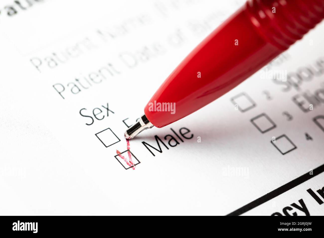 Person checking the male gender box on a document form with red ballpen ...