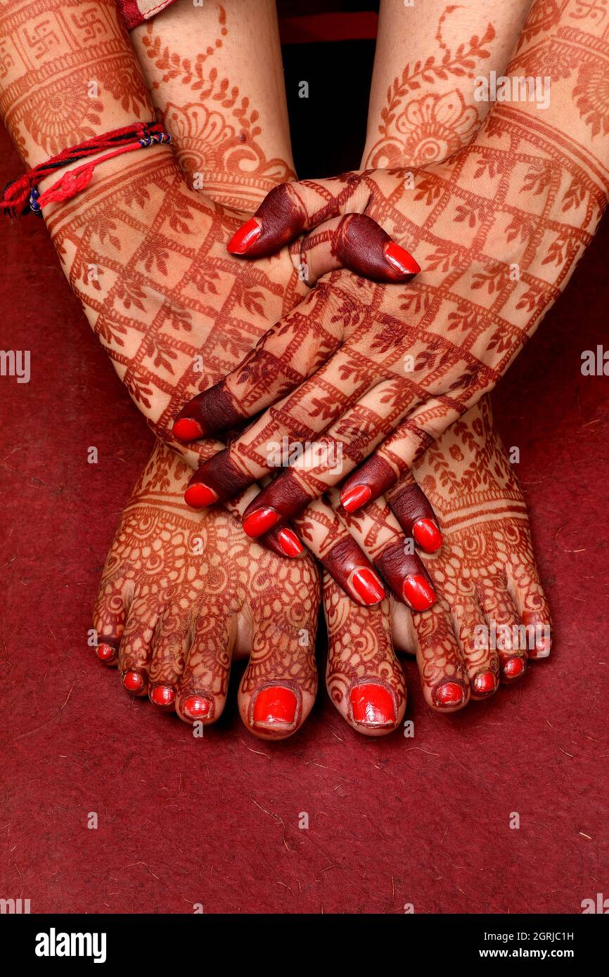 Close-up view of bride with henna on both hands against dark faded ...