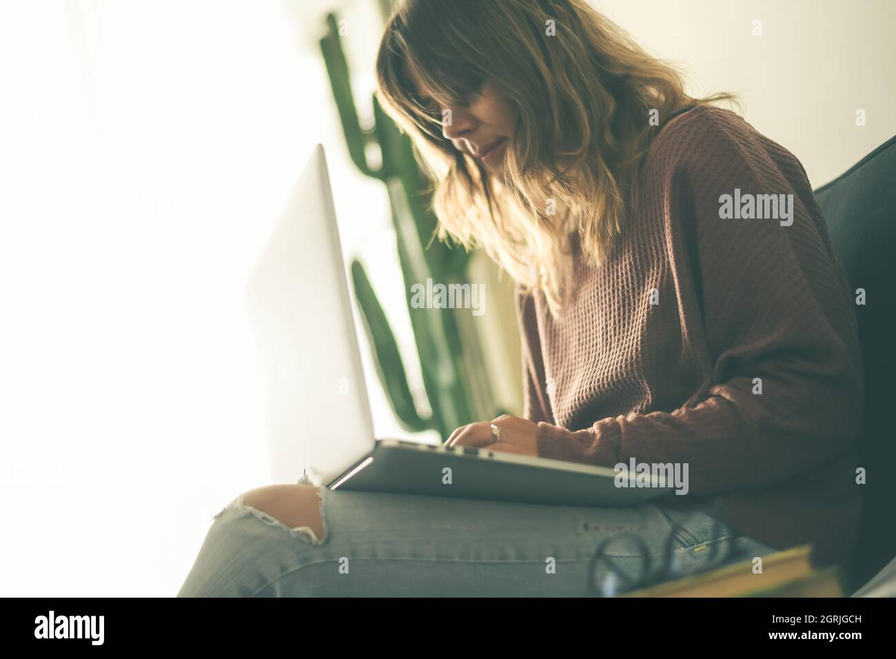 Young woman working on laptop at home. Female hands typing on pc ...