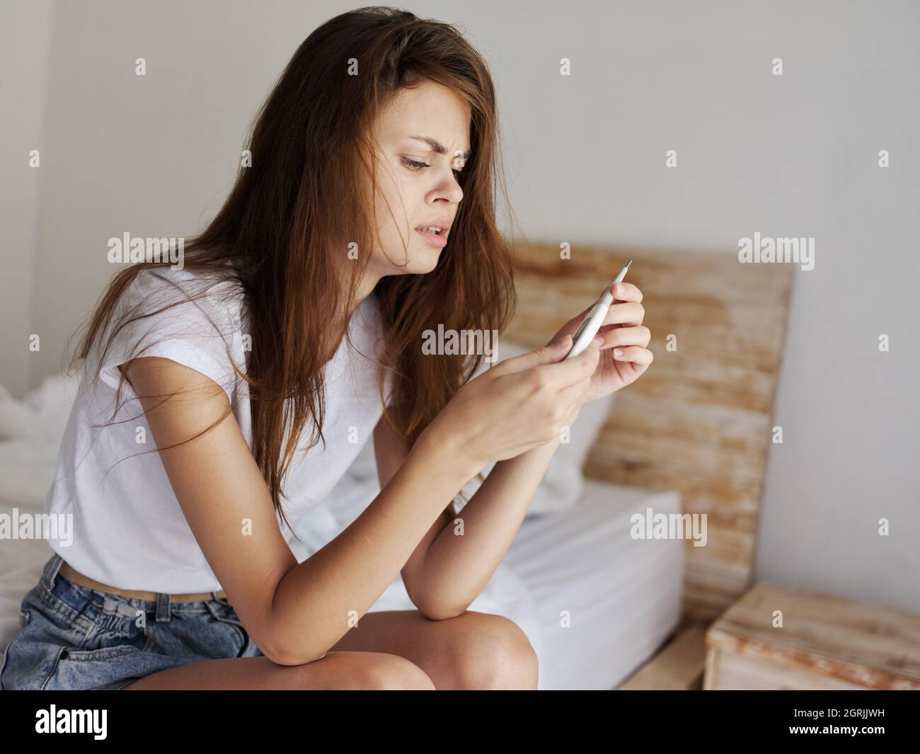 woman in hotel with thermometer in hands upset fever Stock Photo - Alamy