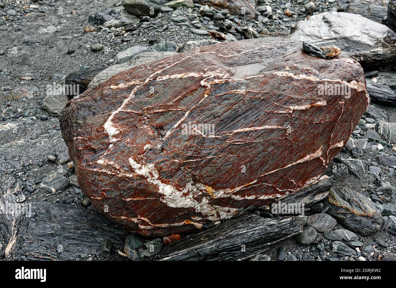 large rock, colorful striations, veins, crystallized minerals, rust ...