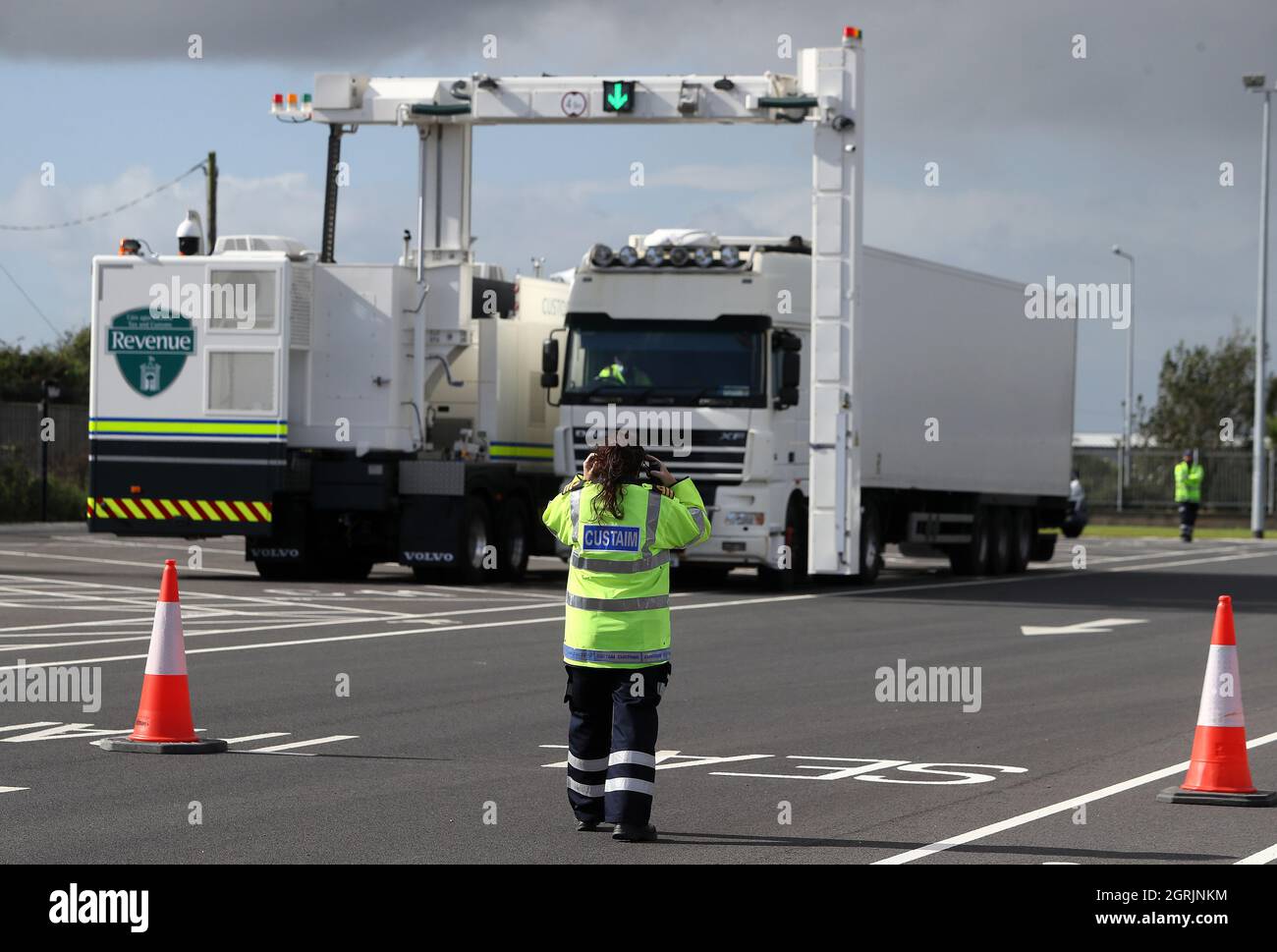 A customs official watches as a truck is scanned by a Customs X-Ray ...