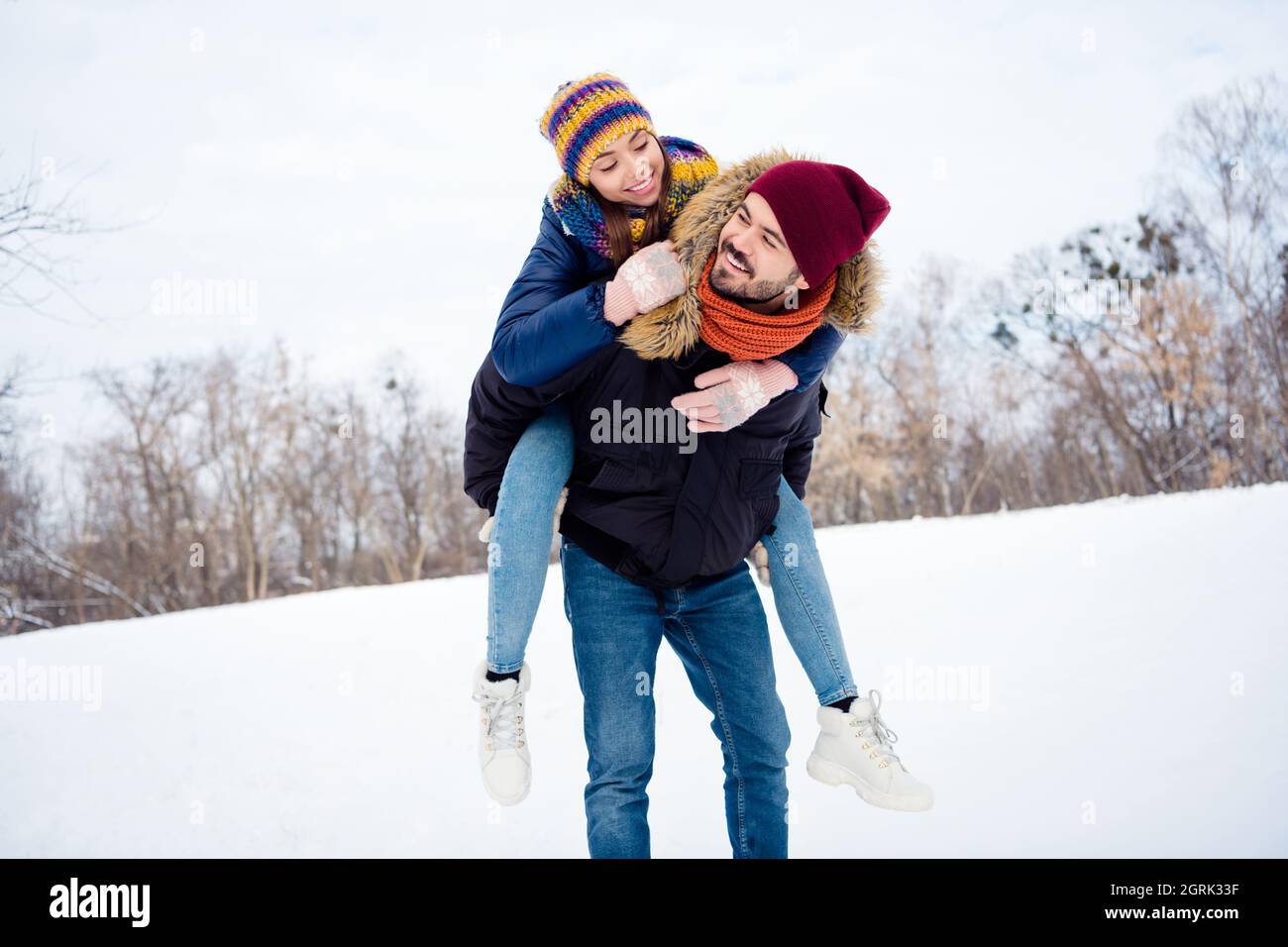 Portrait of positive guy hold on back pretty lady look each other ...