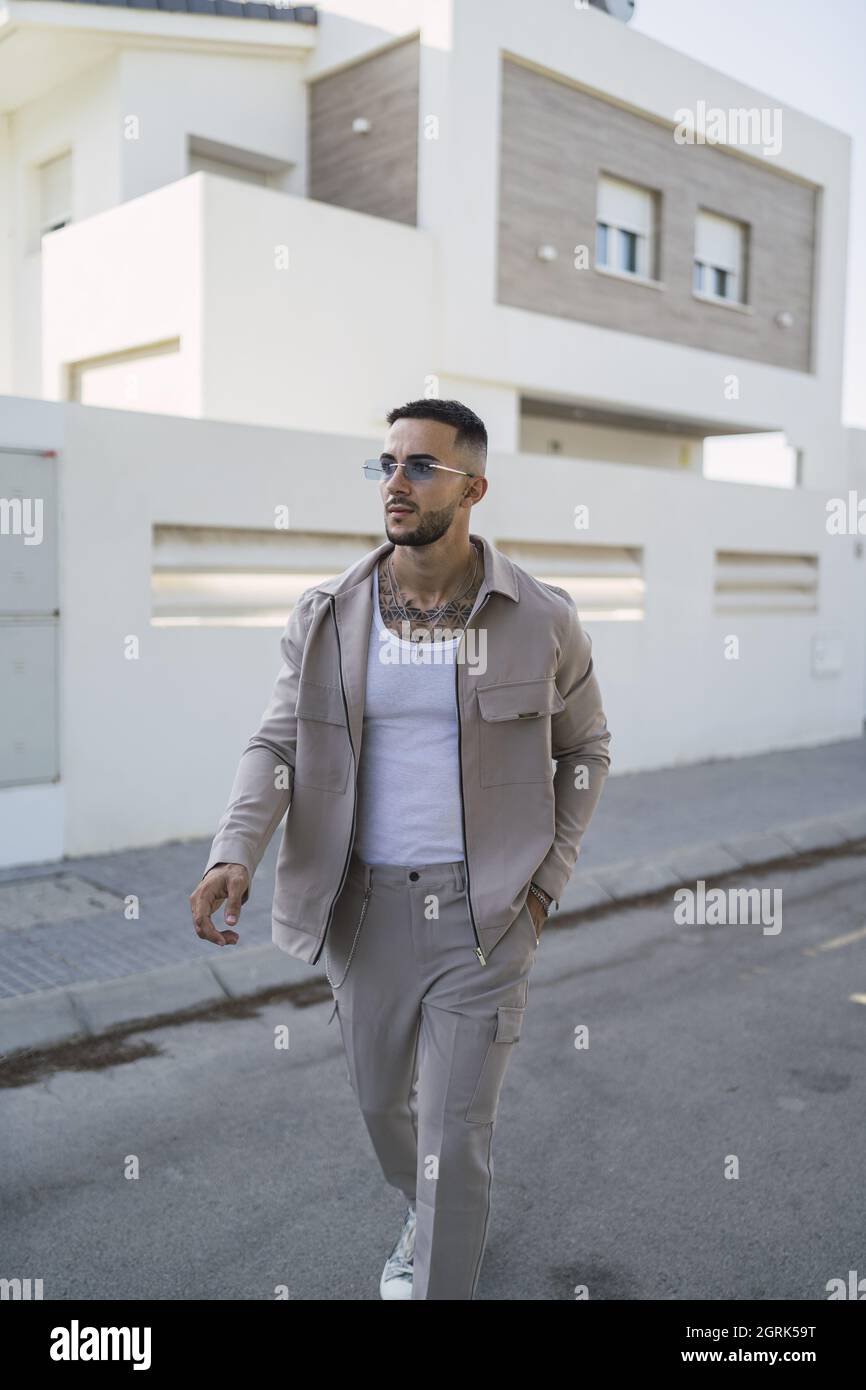 A vertical shot of a young handsome Caucasian male with glasses and in ...