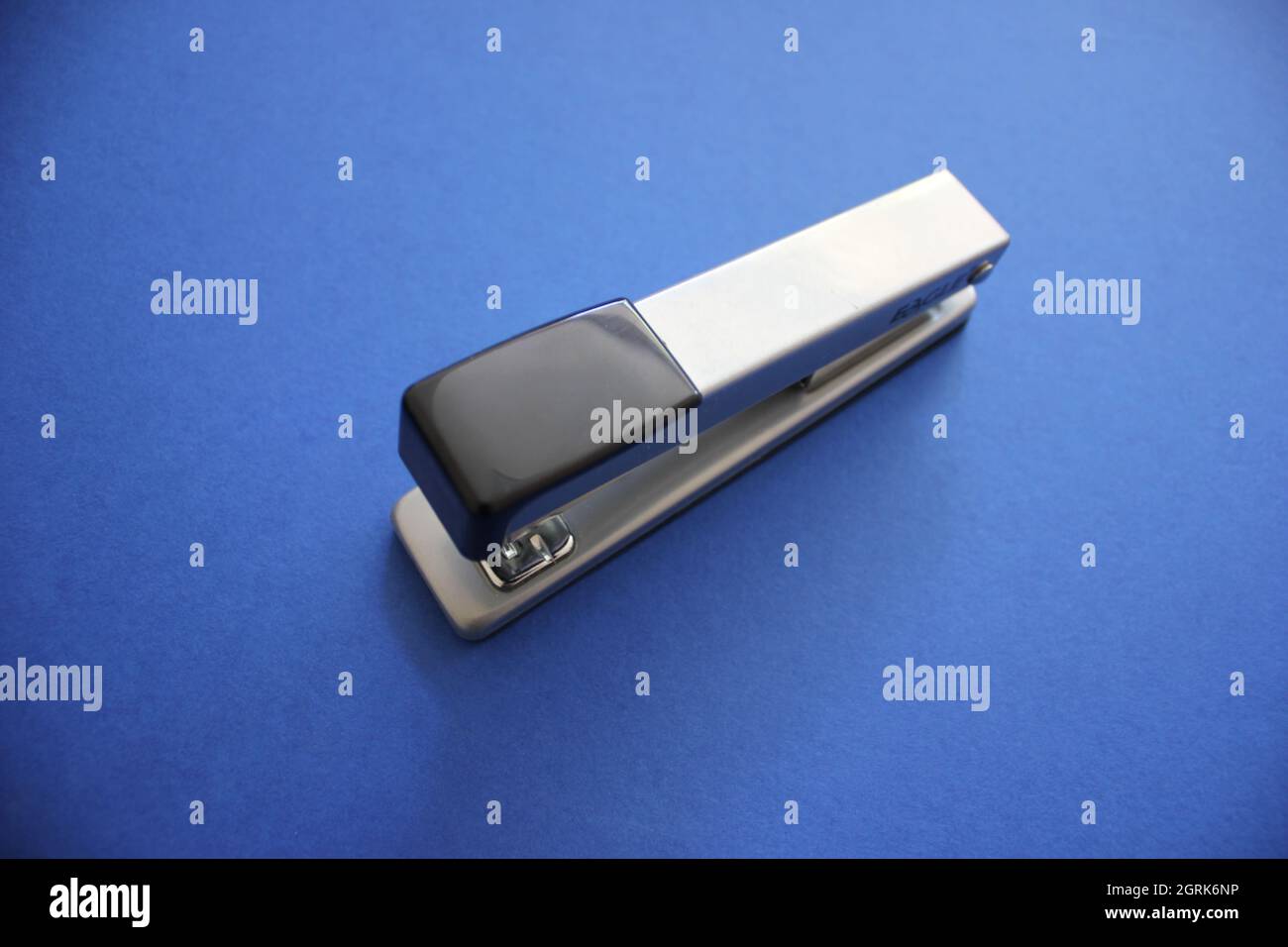stapler on blue background in natural light Stock Photo - Alamy