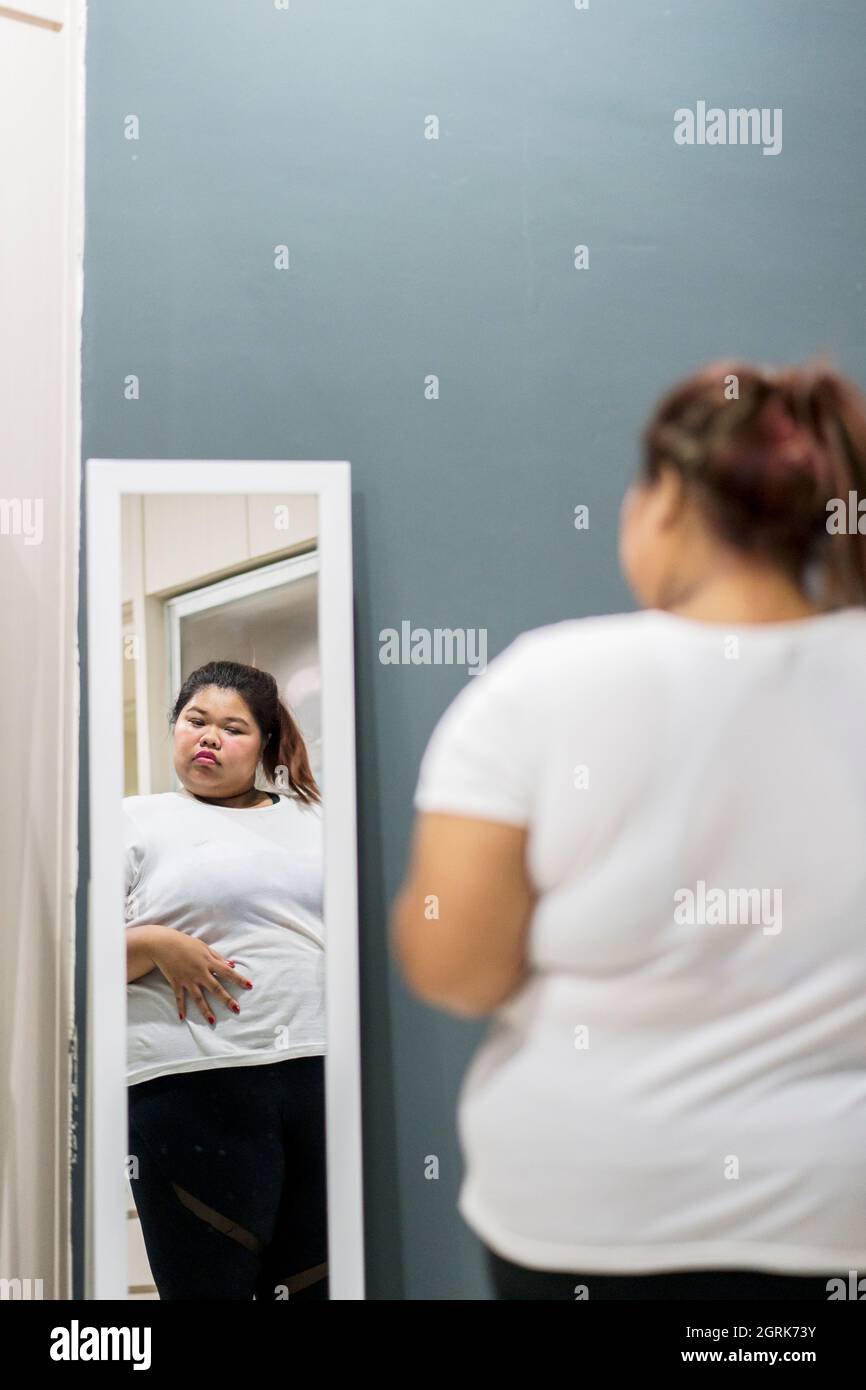 Overweight woman looking in mirror hi-res stock photography and images ...