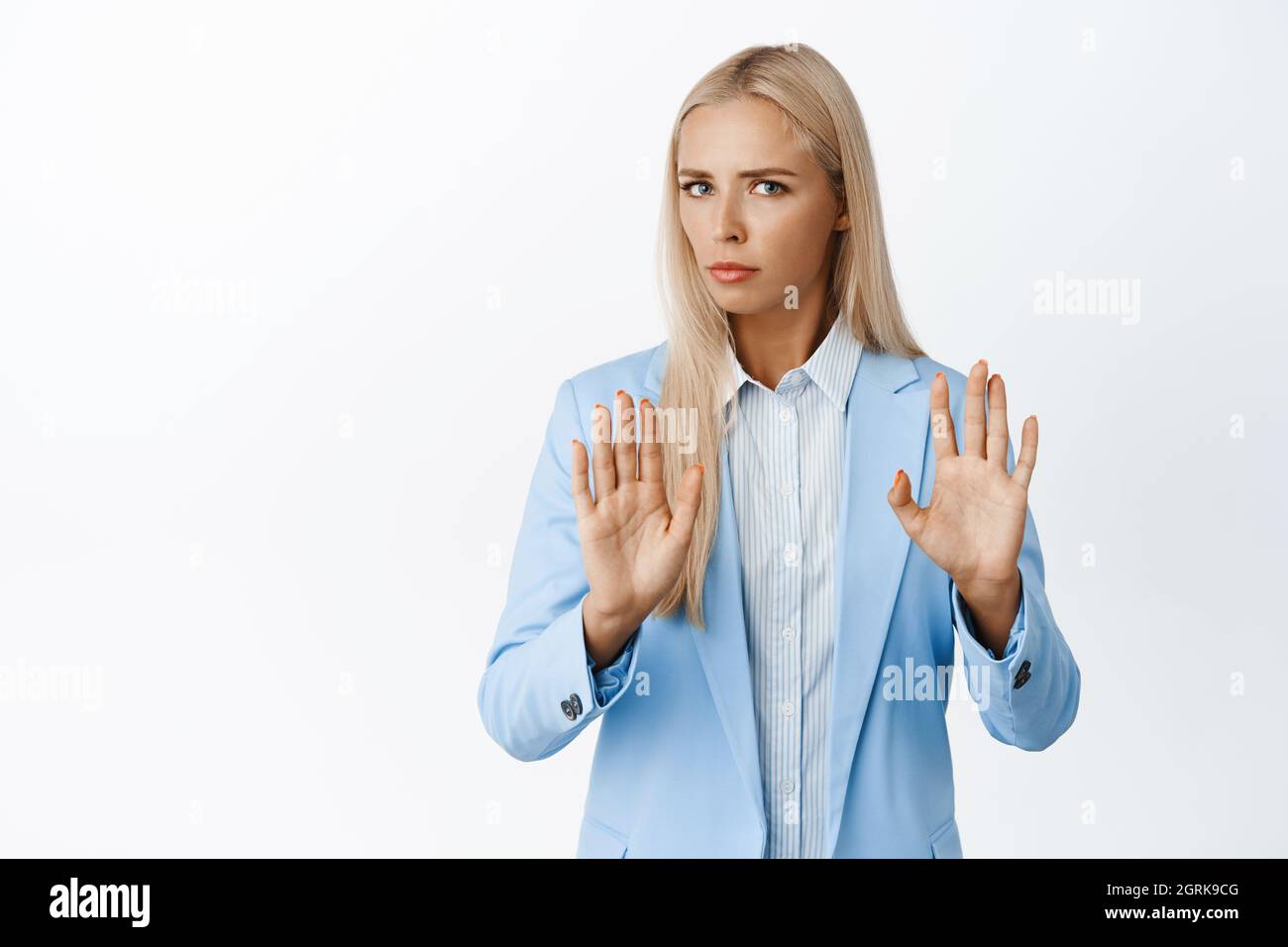 Reluctant corporate woman in blue suit making cross taboo gesture ...
