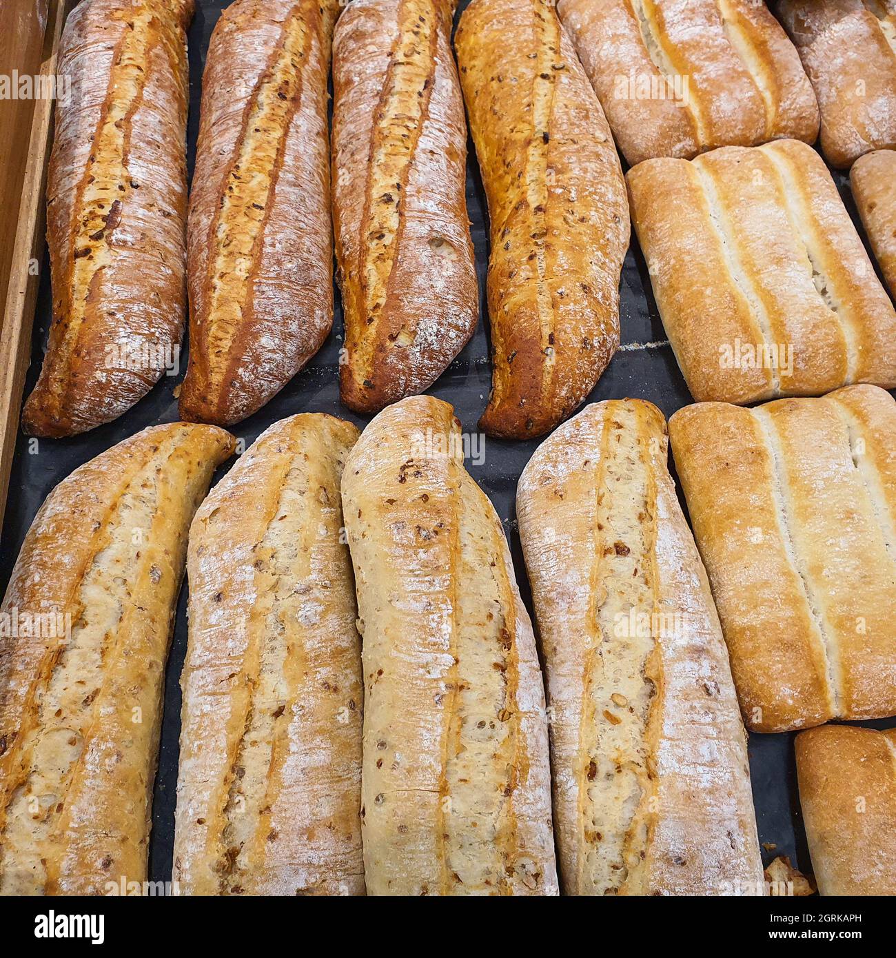 Variety of different types of French baguettes in a bakery or grocery ...