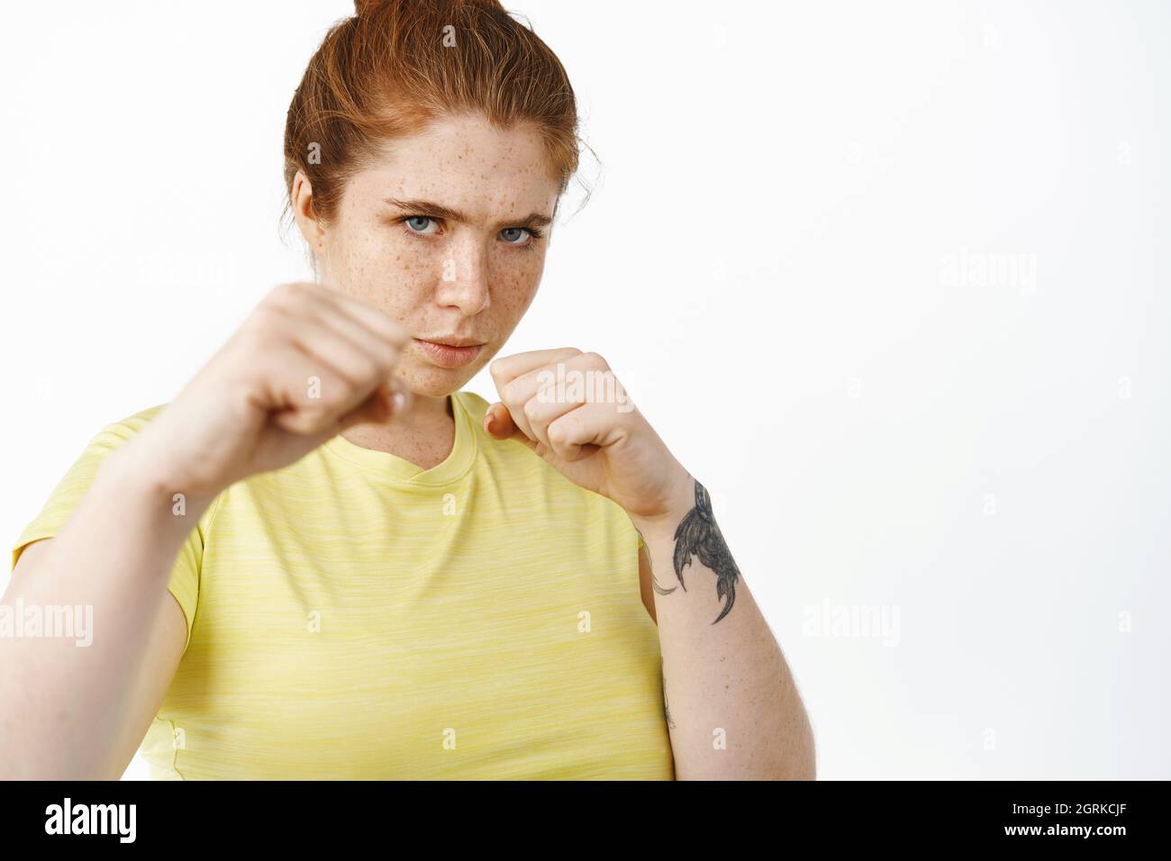Portrait of confident redhead plus size girl boxing, punching with ...