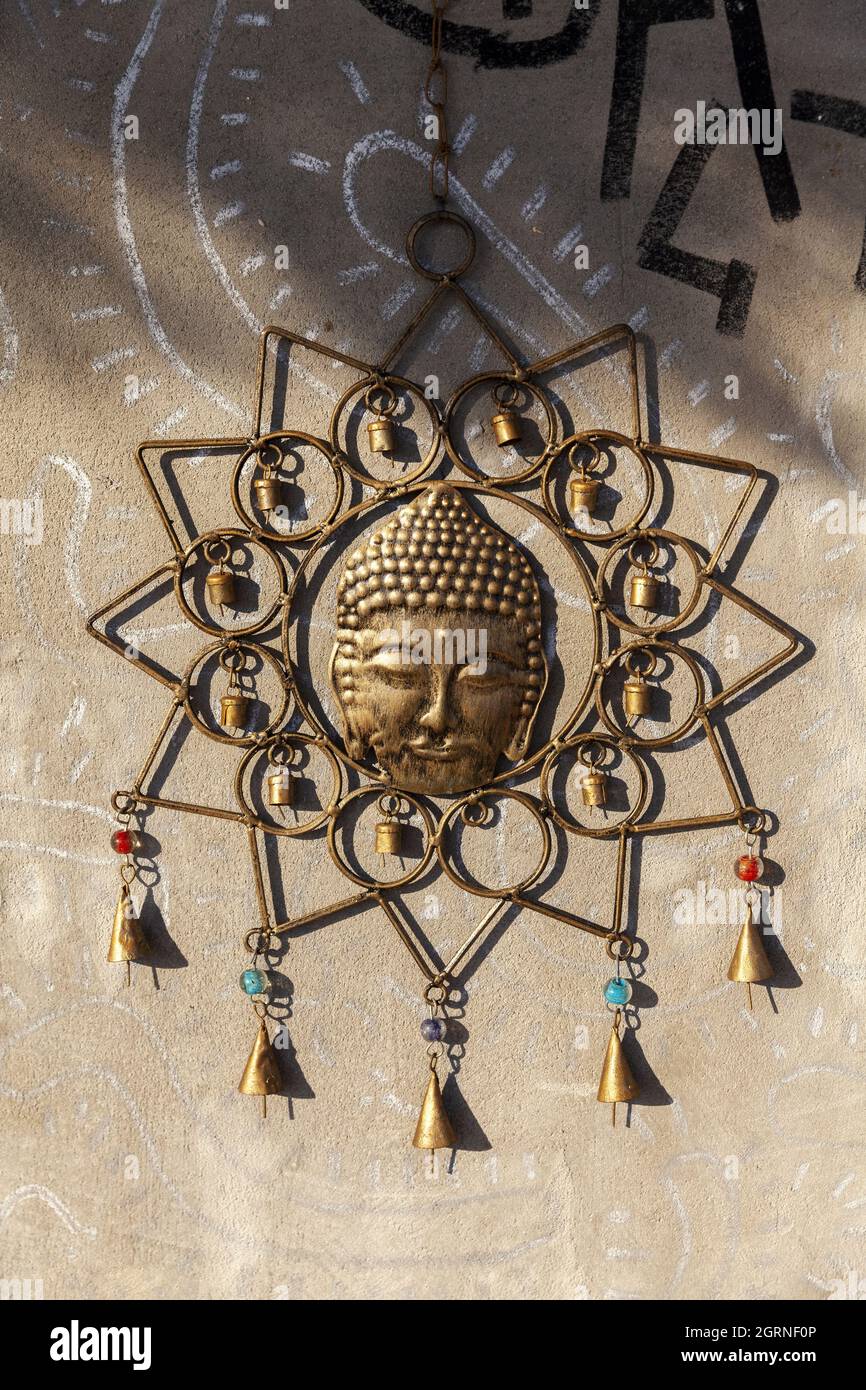 an Indian religious symbol of the Buddha made of brass hung on a wall ...