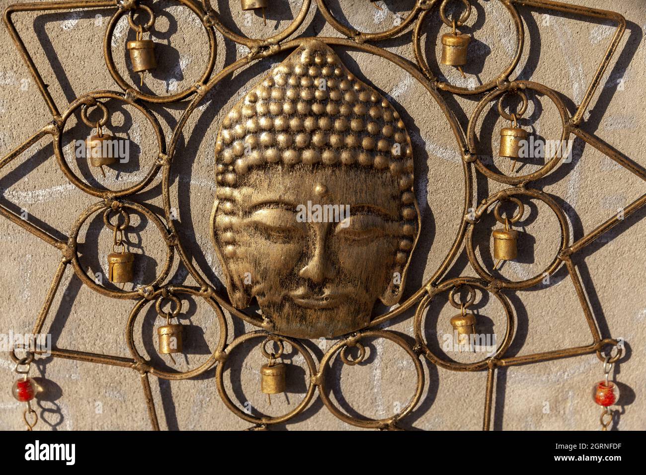 an Indian religious symbol of the Buddha made of brass hung on a wall ...