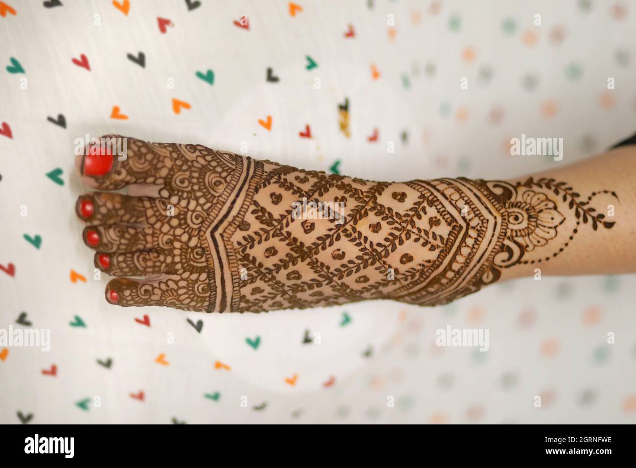 Close-up view of bride with henna on both hands against dark faded ...