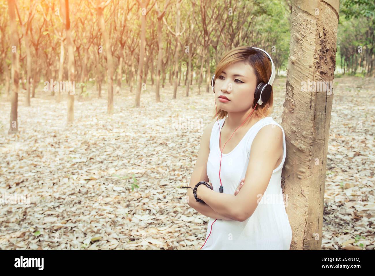 Woman Listening Music Against Trees In Forest Stock Photo - Alamy