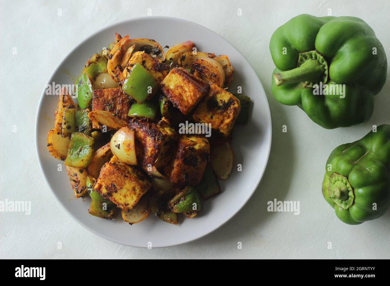 Cottage cheese and bell pepper cubes are marinated and fried on a ...