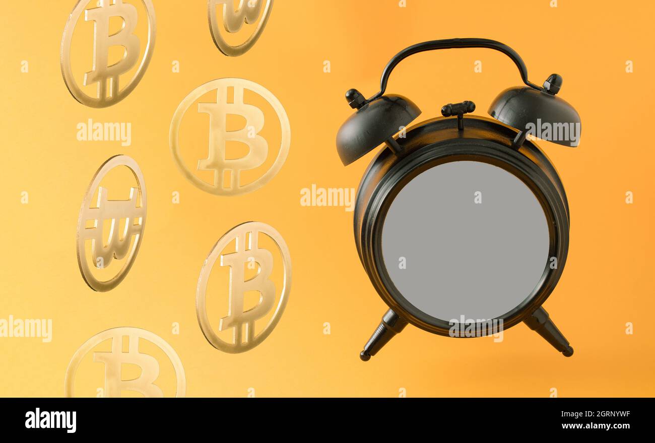 Old brown clock with blank space and bitcoins flying on a orange ...