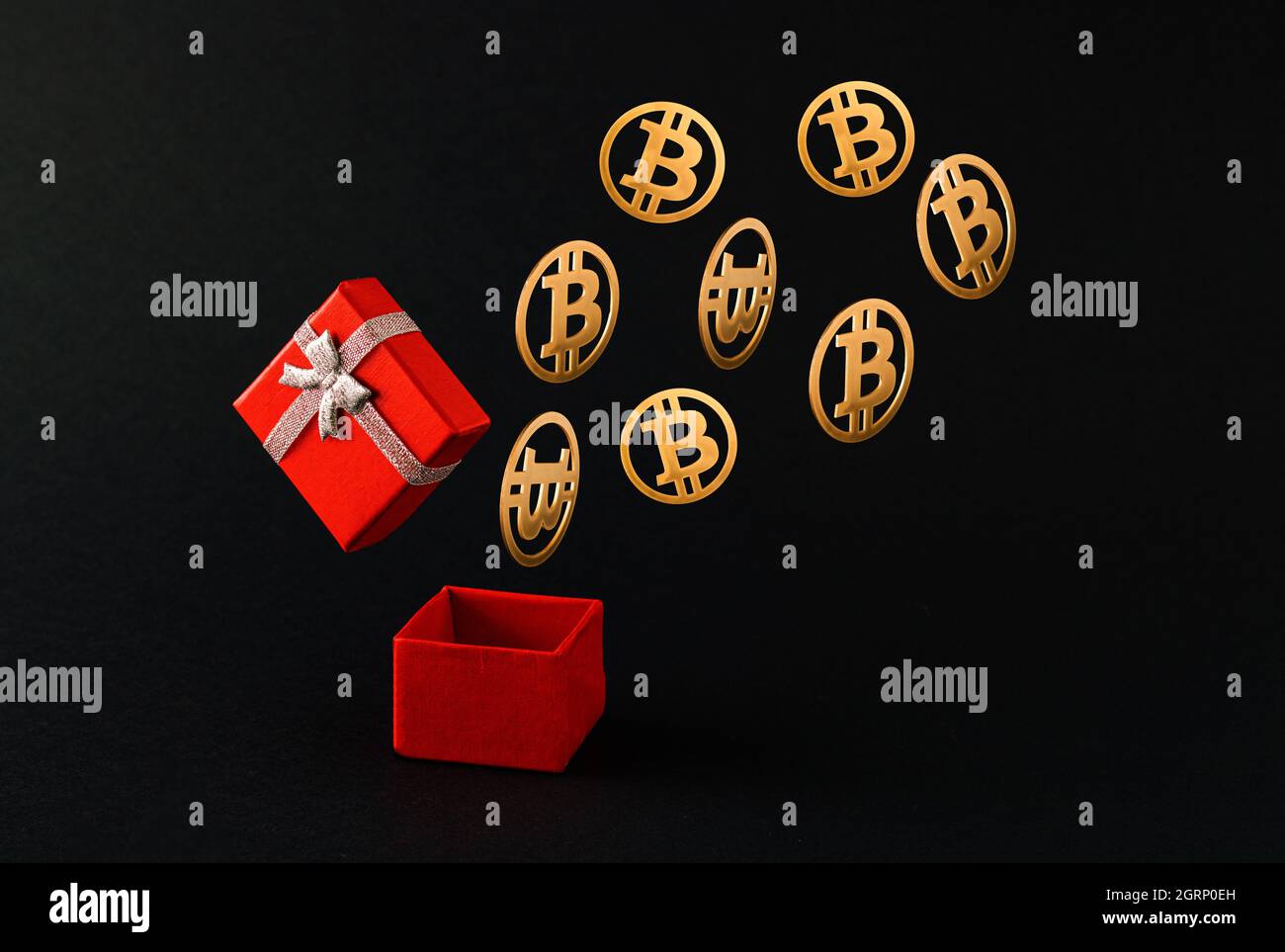 Open gift box with bitcoins flying on a black background. Price ...