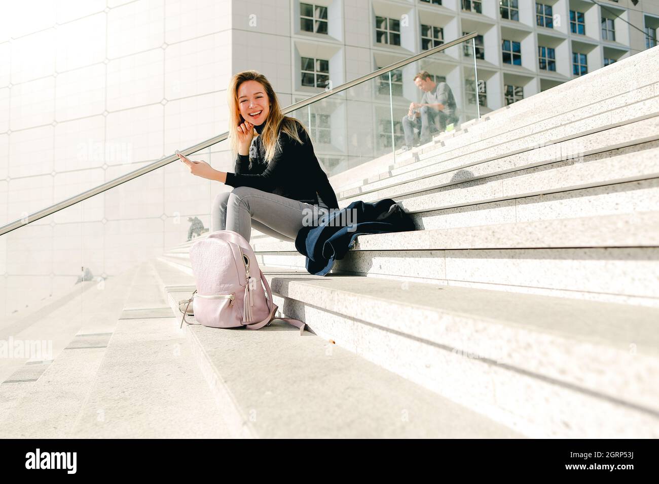 Young girl sitting on stairs and using smartphone Stock Photo - Alamy