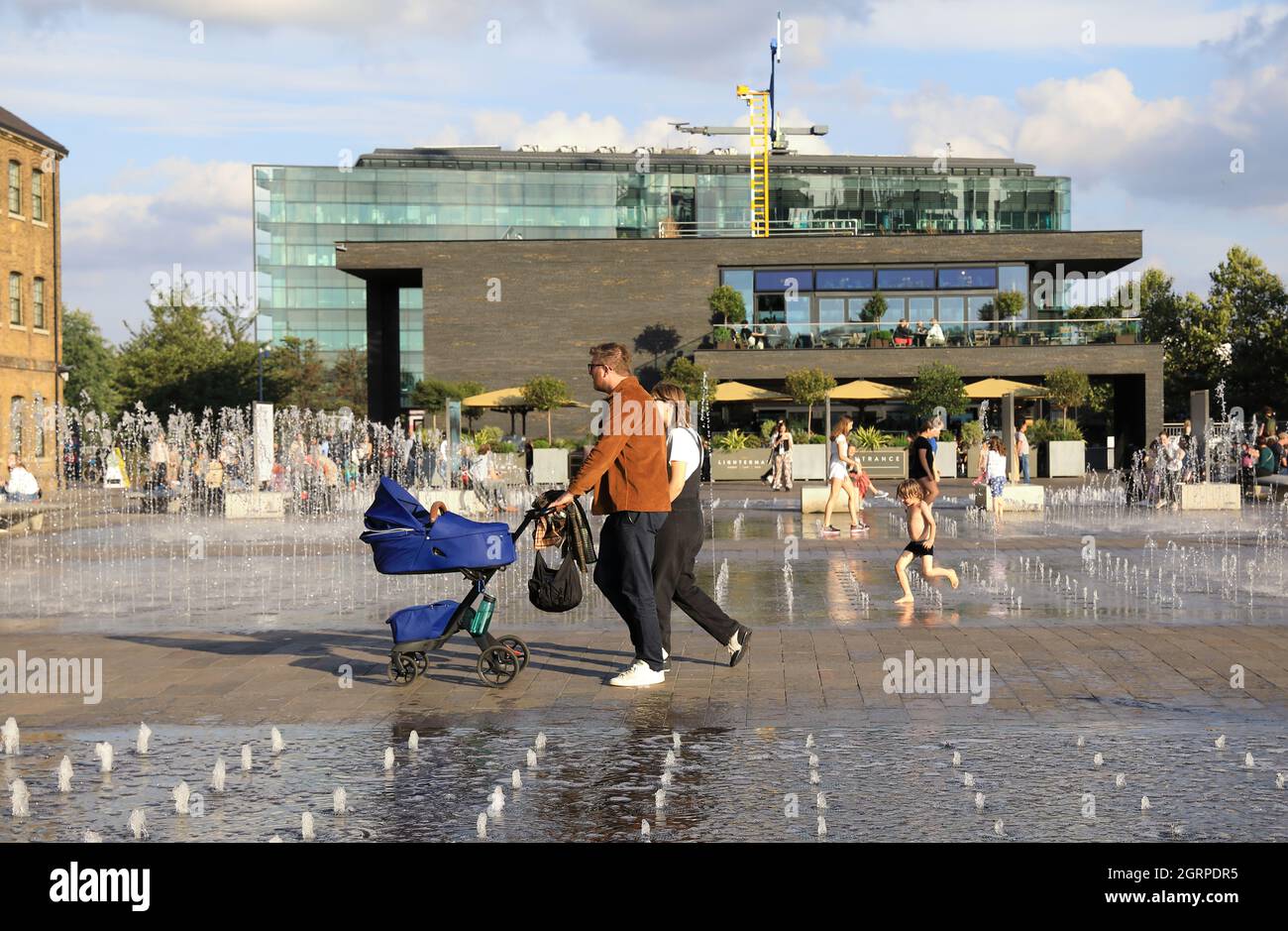Autumn sunshine on the fountains in Granary Square, with the Lighterman ...