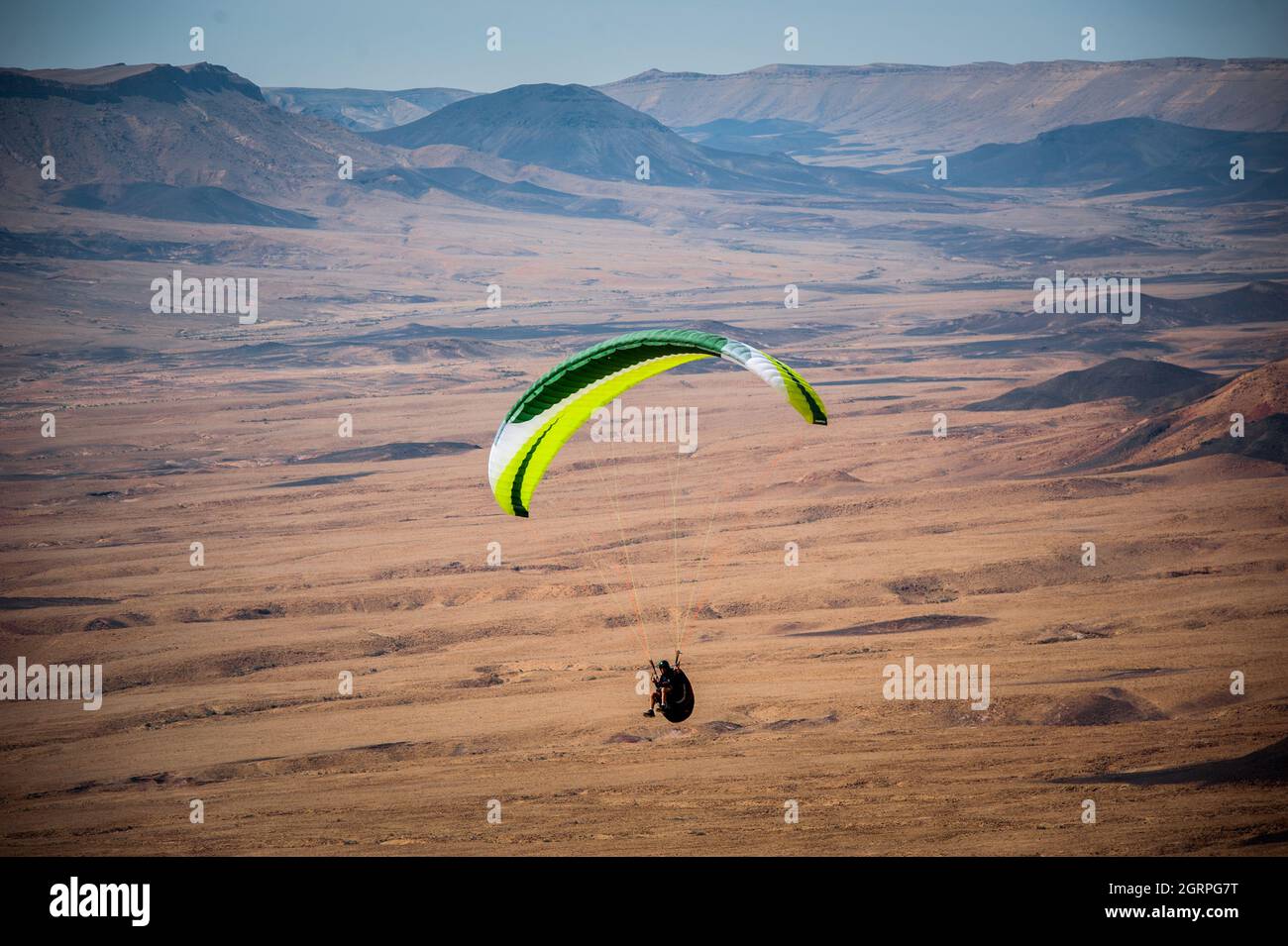 A paraglider soars over the Israeli desert Stock Photo - Alamy