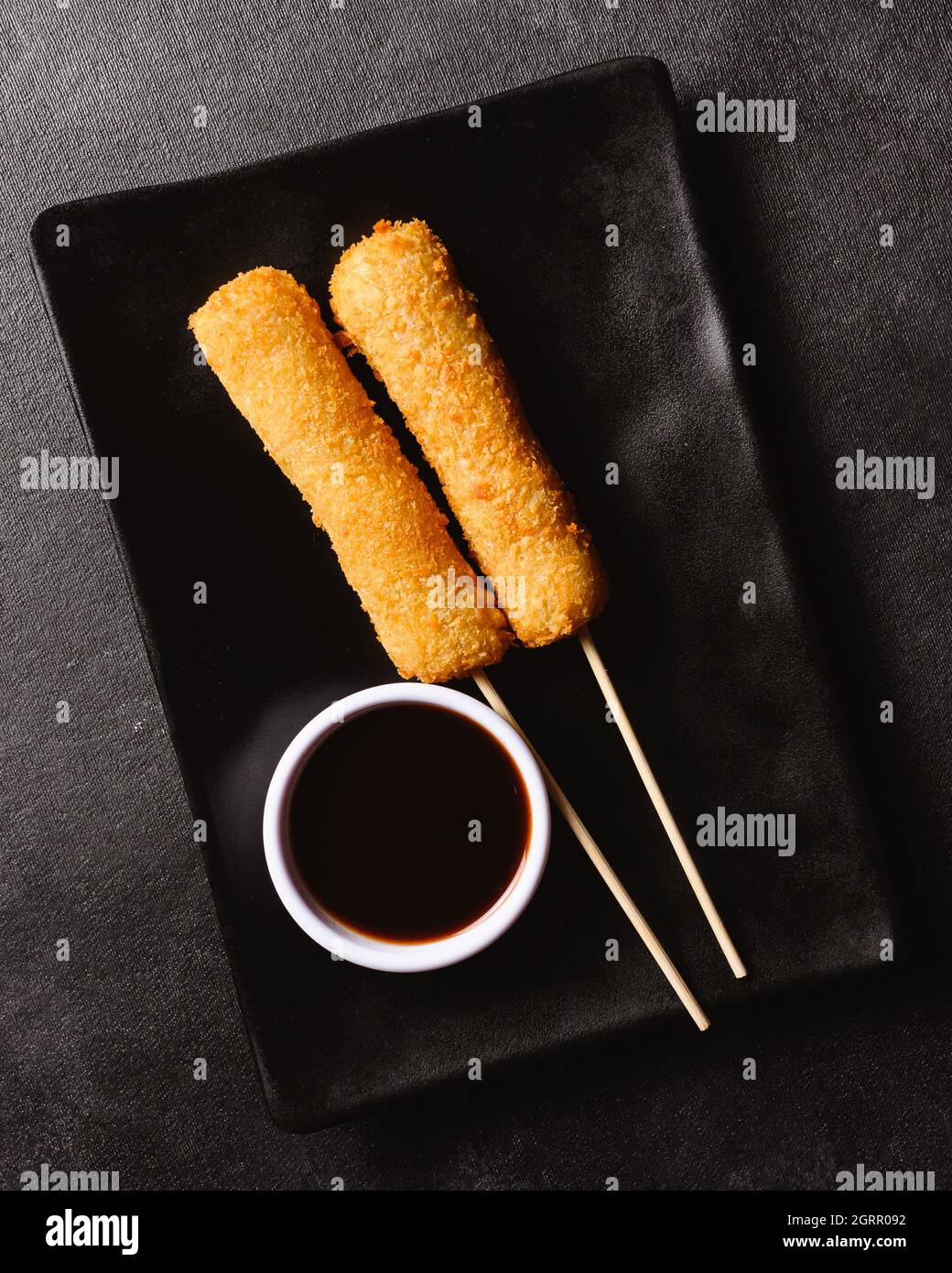 Vertical top view shot of fish fingers with sticks, and a sauce in a ...
