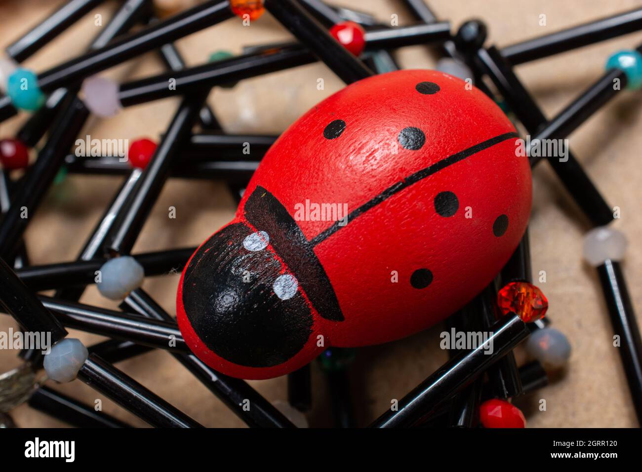 Closeup of a wooden painted ladybug and plastic sticks Stock Photo - Alamy