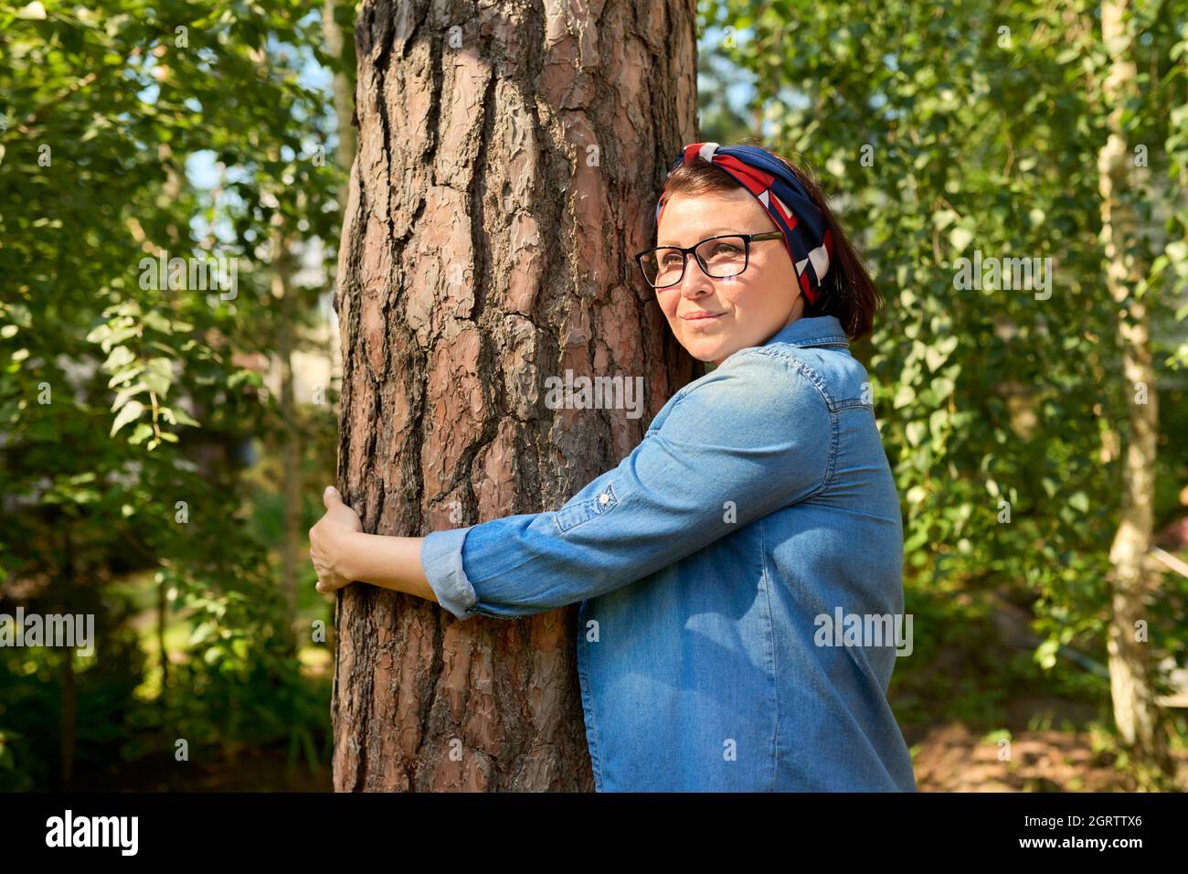 Middle aged woman hugging a tree, energy of nature Stock Photo - Alamy