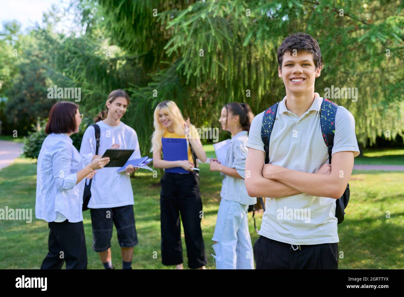 Portrait of male student in park campus, group of teenagers with ...
