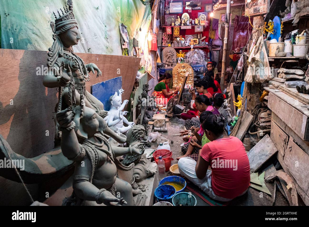 A woman artist along with her students make final touches to idols at ...