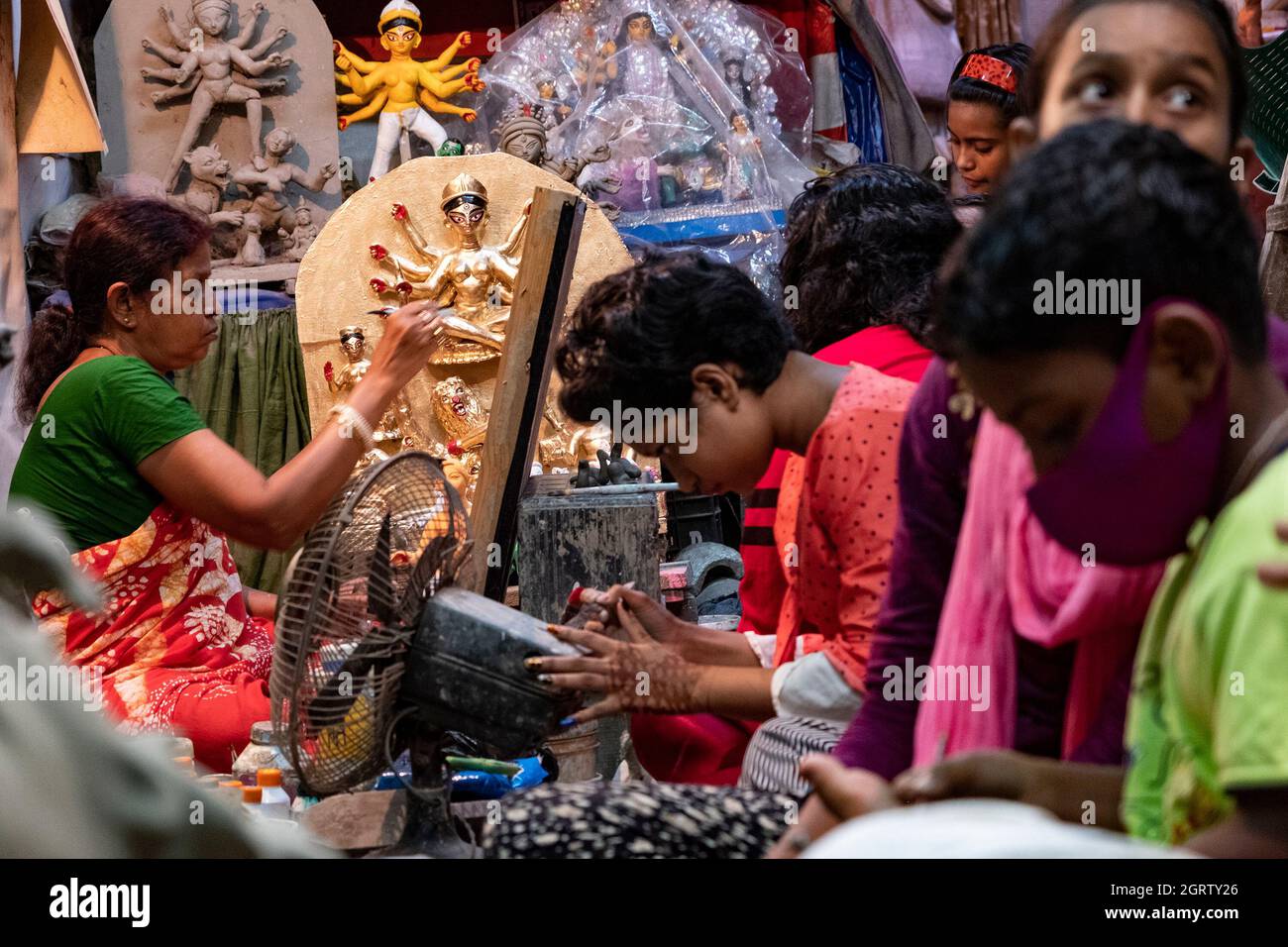 A woman artist along with her students seen make final touches to idols ...