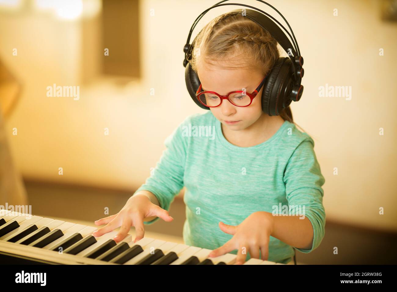 A girl with Down syndrome learns to play the piano and listens to music Stock Photo - Alamy