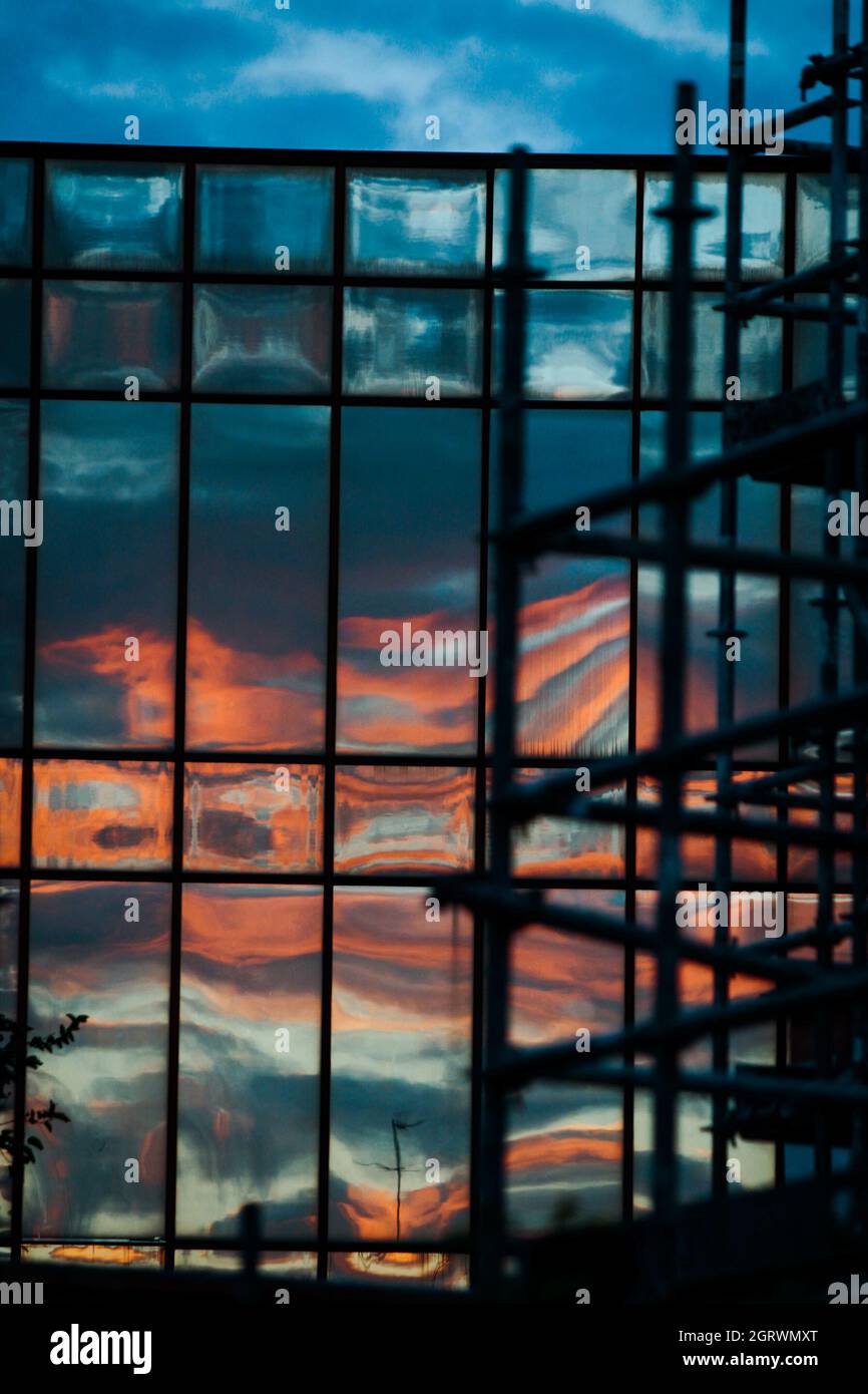 Dramatic sunset reflected on the glass facade of a modern building ...
