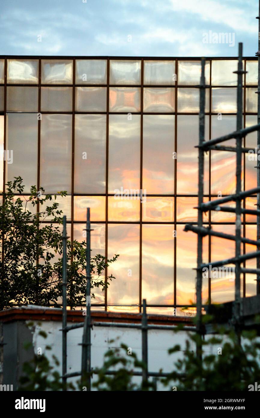 Dramatic sunset reflected on the glass facade of a modern building ...