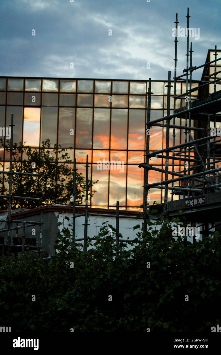 Dramatic sunset reflected on the glass facade of a modern building ...