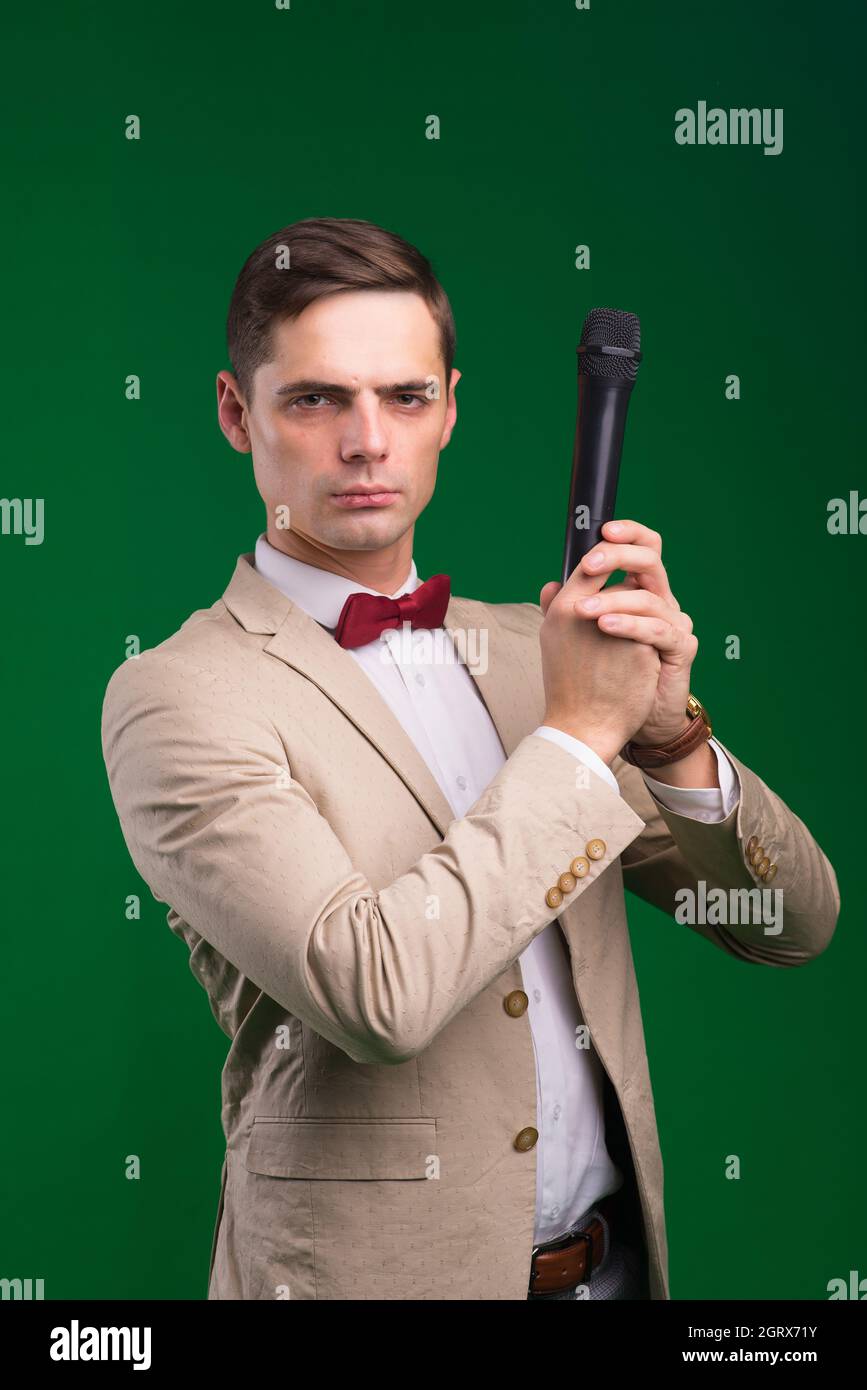 The entertainer. Young elegant talking man holding microphone, Isolated ...