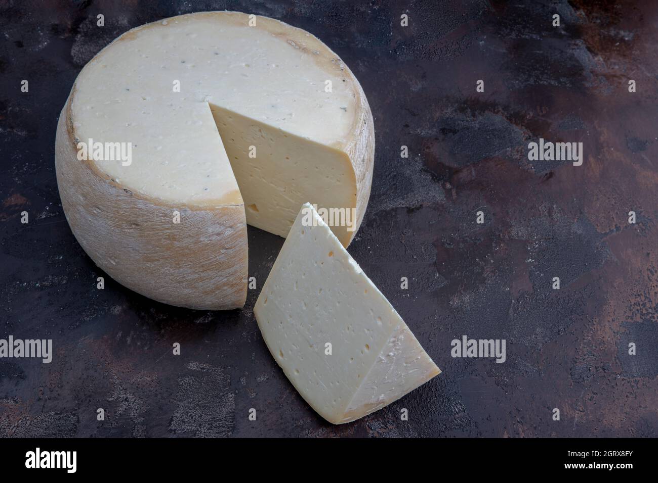 Old cheddar cheese. Wheel aged cheese. Aged cheddar cheese wheel on ...
