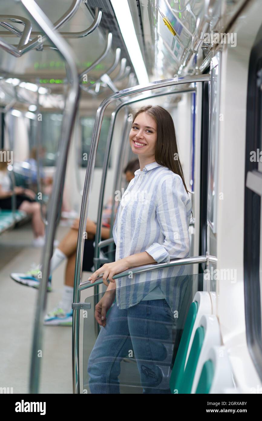 Happy young girl inside metro subway carriage student return home from ...