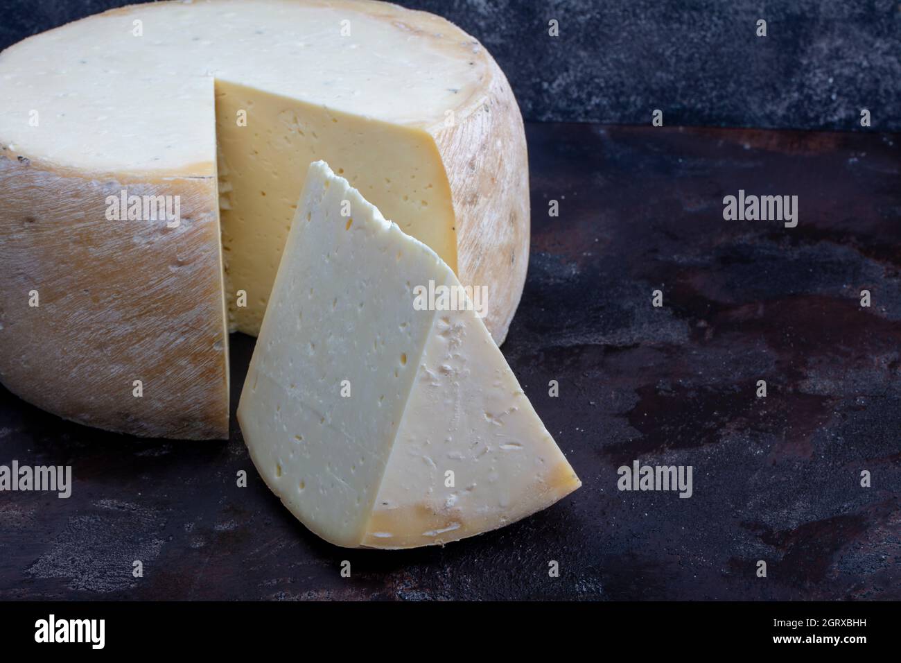 Old cheddar cheese. Wheel aged cheese. Aged cheddar cheese wheel on ...