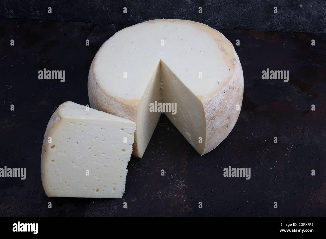 Old cheddar cheese. Wheel aged cheese. Aged cheddar cheese wheel on ...