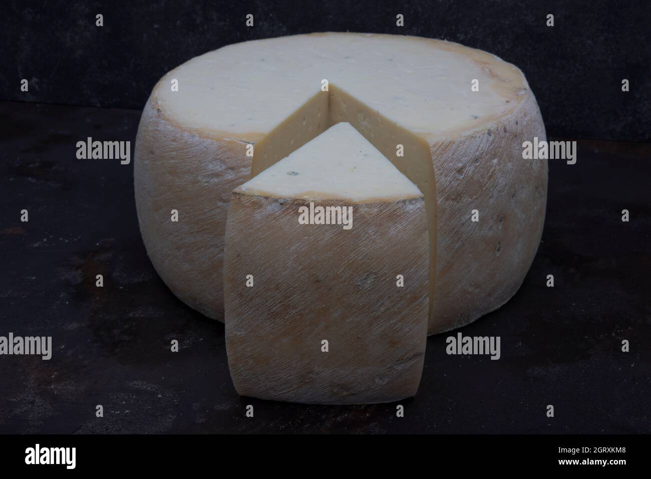 Old cheddar cheese. Wheel aged cheese. Aged cheddar cheese wheel on ...