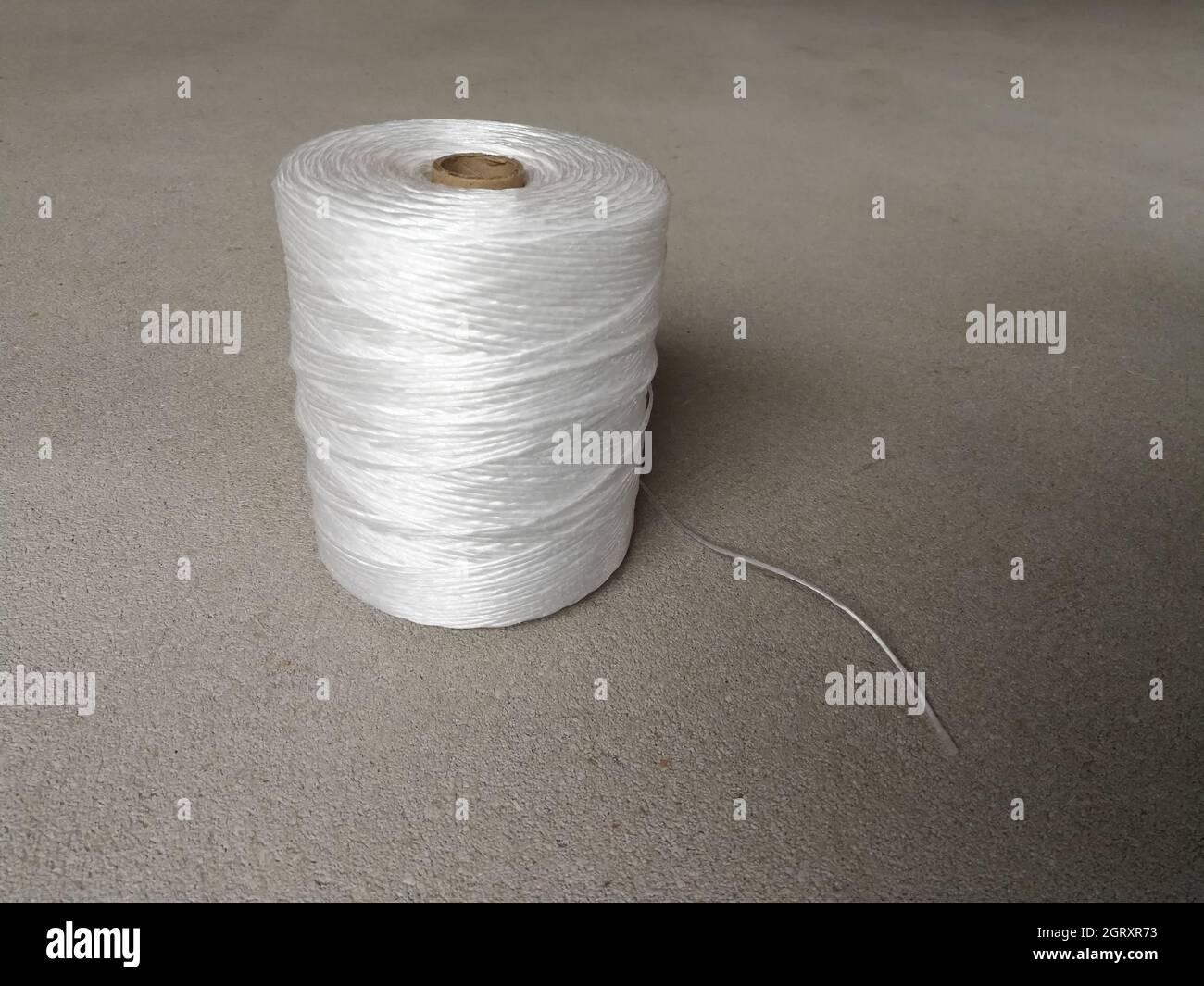 Reel of synthetic polyester construction cord on the concrete floor for ...