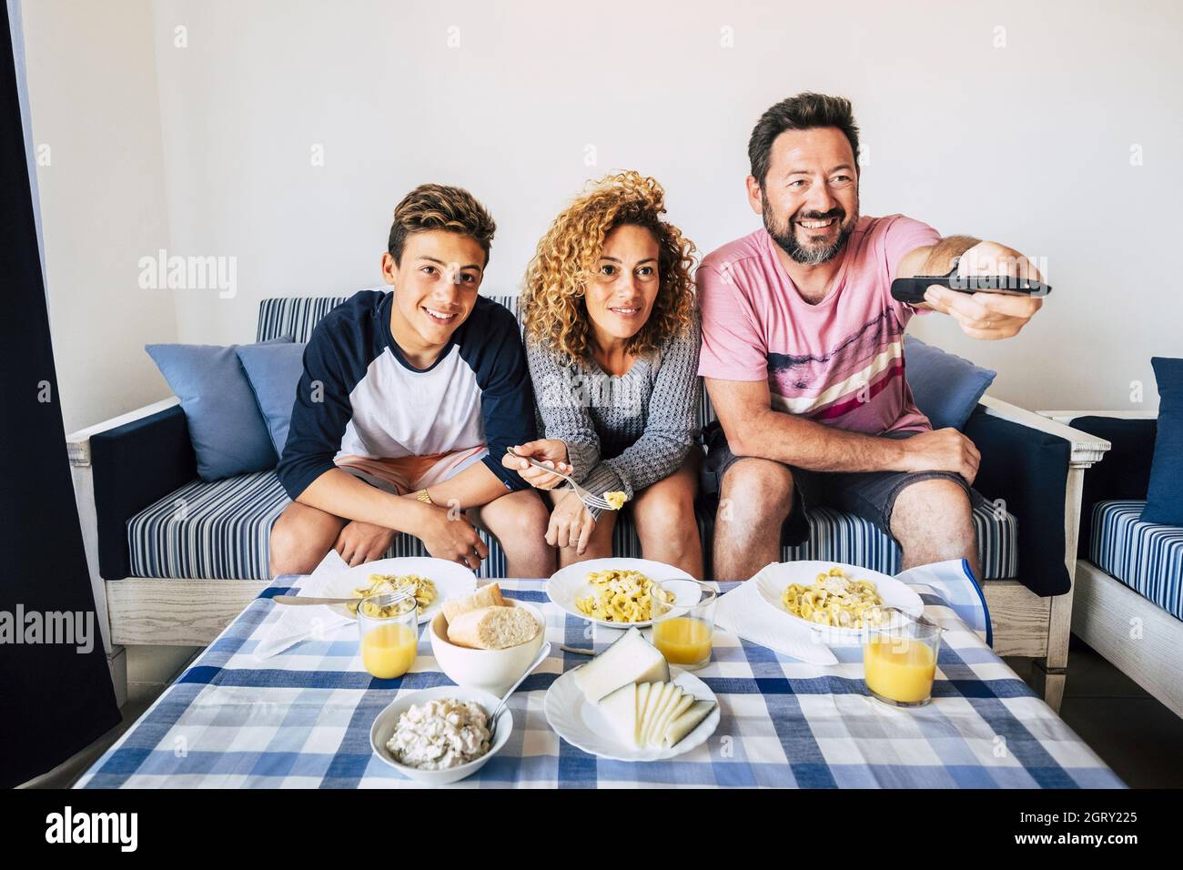 Family Watching Tv While Having Food At Home Stock Photo - Alamy
