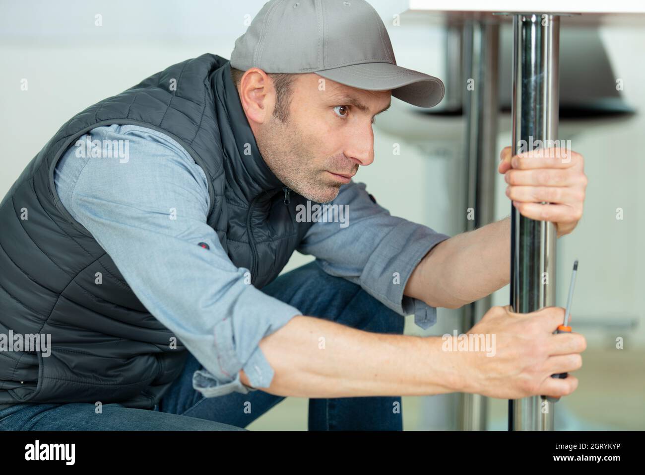 horizontal image of man fixing a table Stock Photo - Alamy