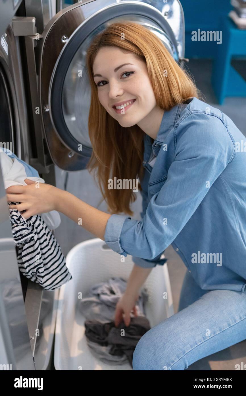 Young woman loading washing machine hi-res stock photography and images ...