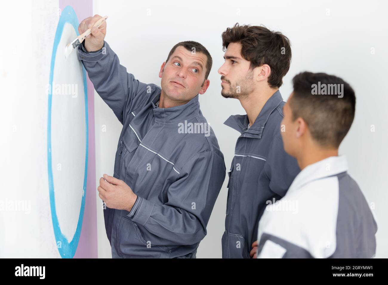 teacher and apprentice working on a wall Stock Photo - Alamy