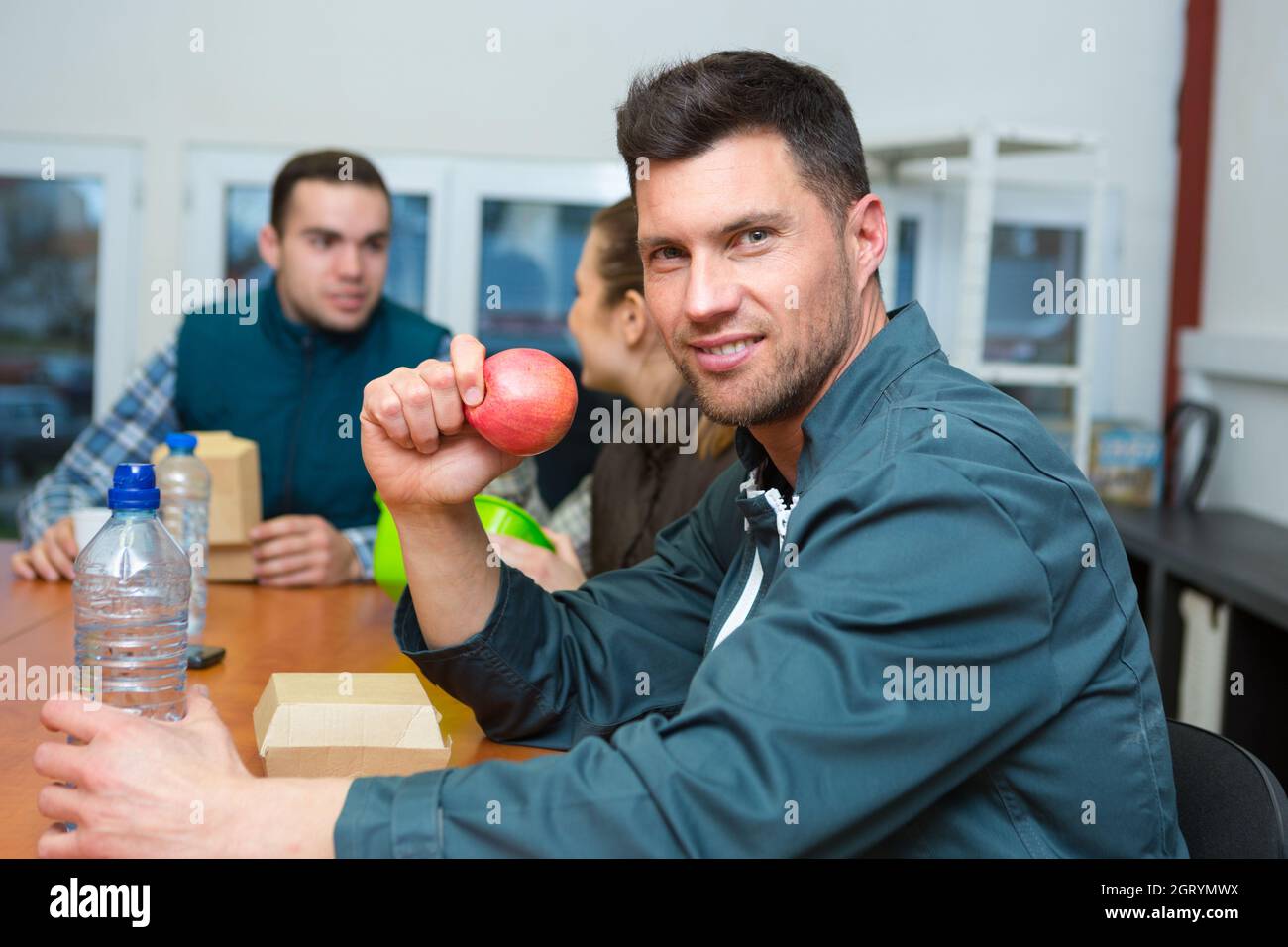 portrait of manual worker eating apple on lunch break Stock Photo - Alamy