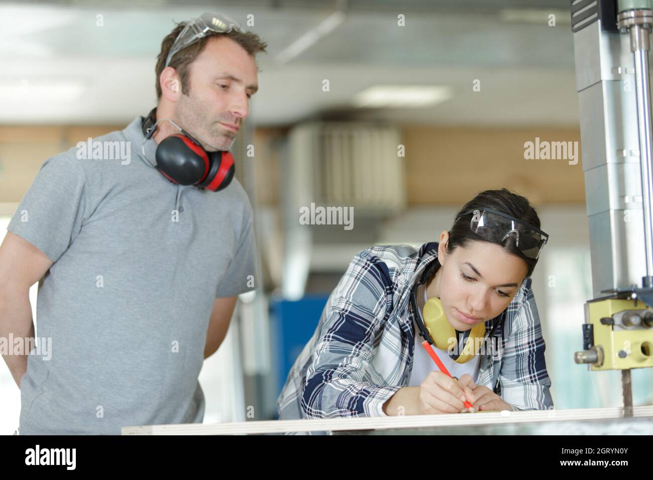 carpenter and apprentice learning how to measure wood Stock Photo - Alamy