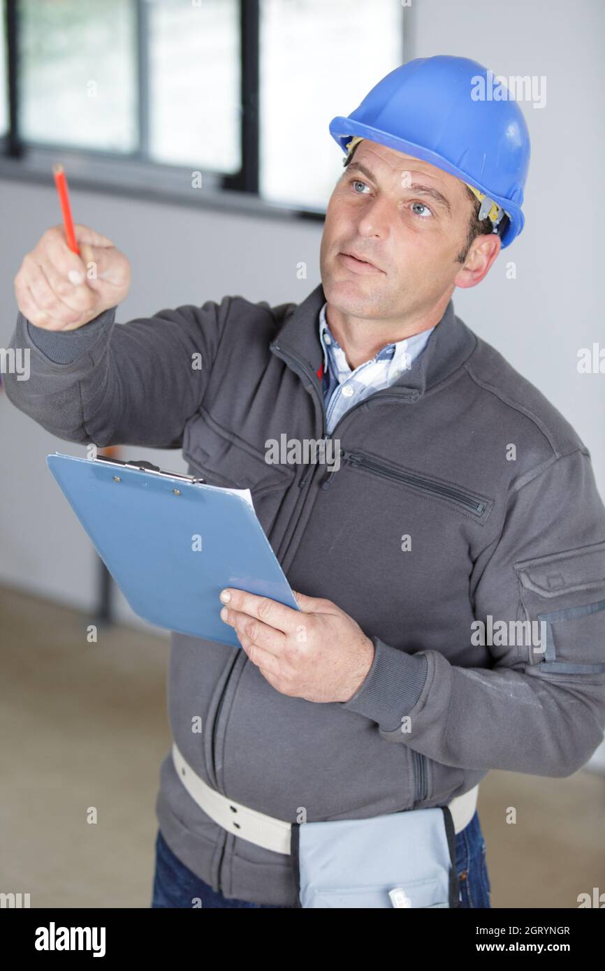 engineer man wearing helmet holding clipboard pointing Stock Photo - Alamy
