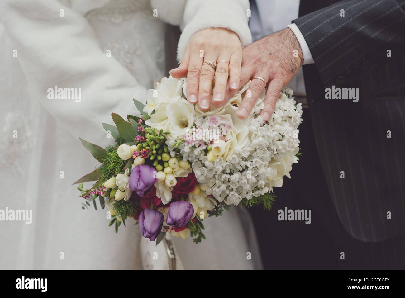 Bridal couple holding hands, showing wedding rings Stock Photo - Alamy